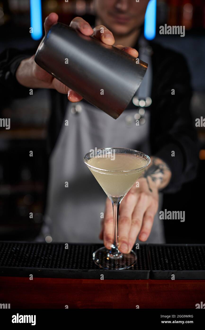 male barman hands is making cocktail with steel shaker Stock Photo - Alamy