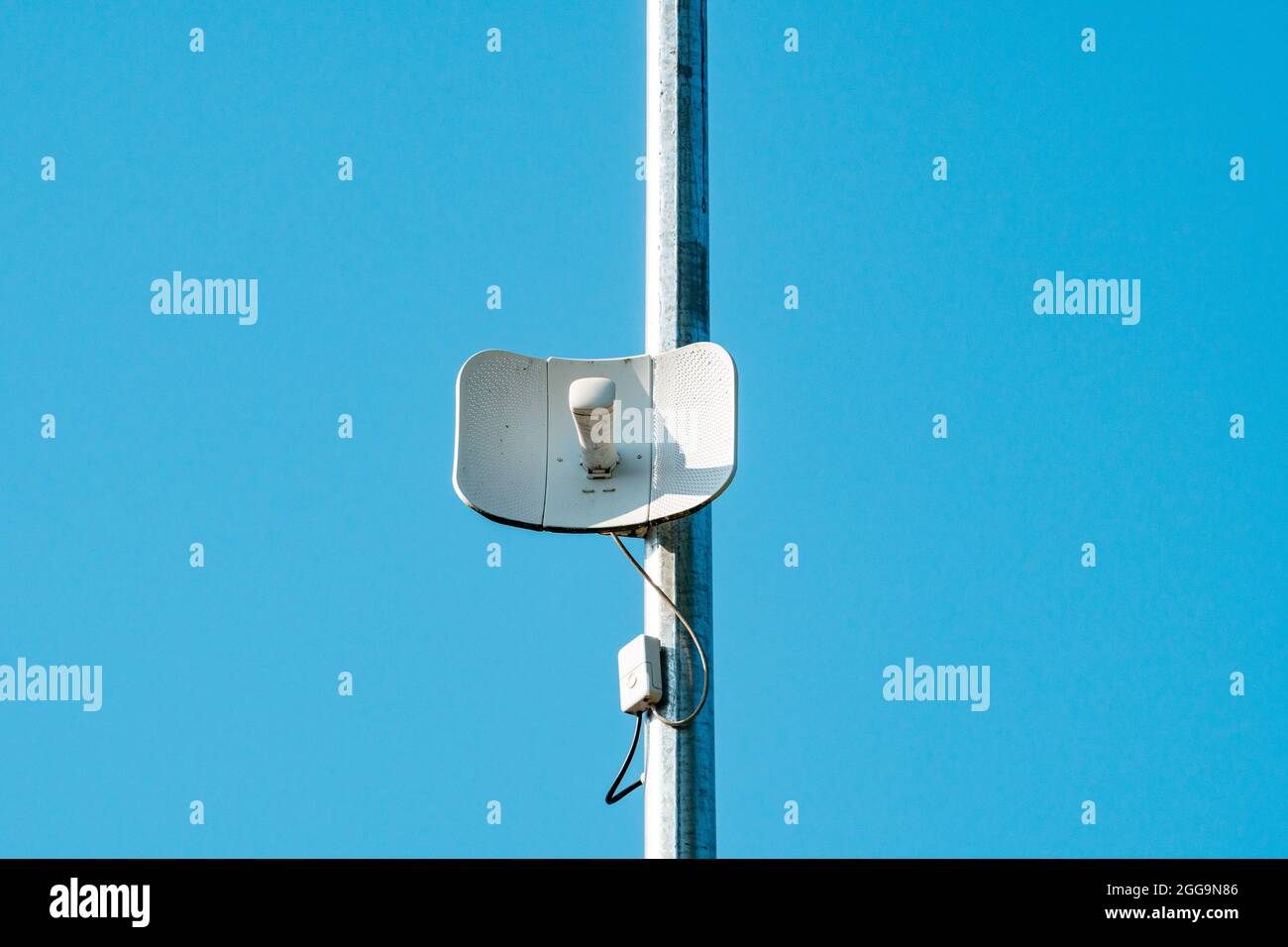 Wireless internet access point antenna on a street pole over a blue sky ...