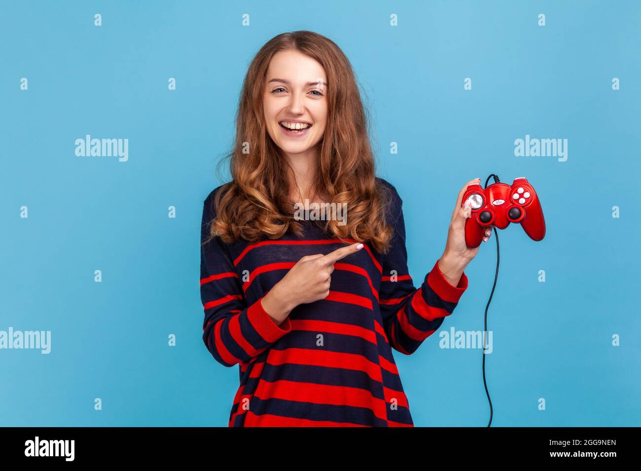 Positive smiling woman gamer with wavy hair wearing striped casual ...