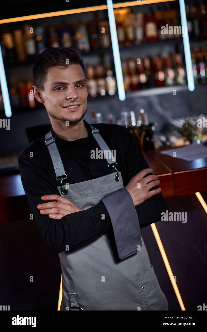 Handsome barman in apron standing at the bar counter Stock Photo - Alamy