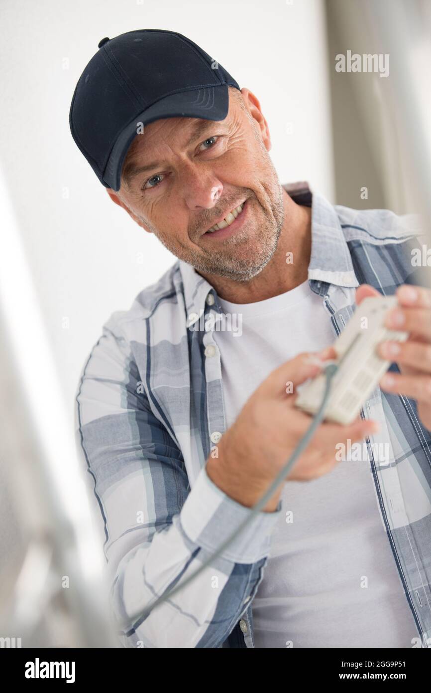 laughing man holding electrical cables Stock Photo - Alamy