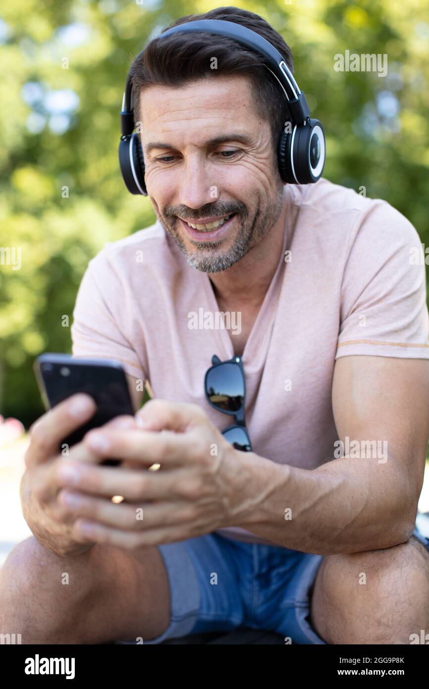 Guy using phone with headset on street hi-res stock photography and ...