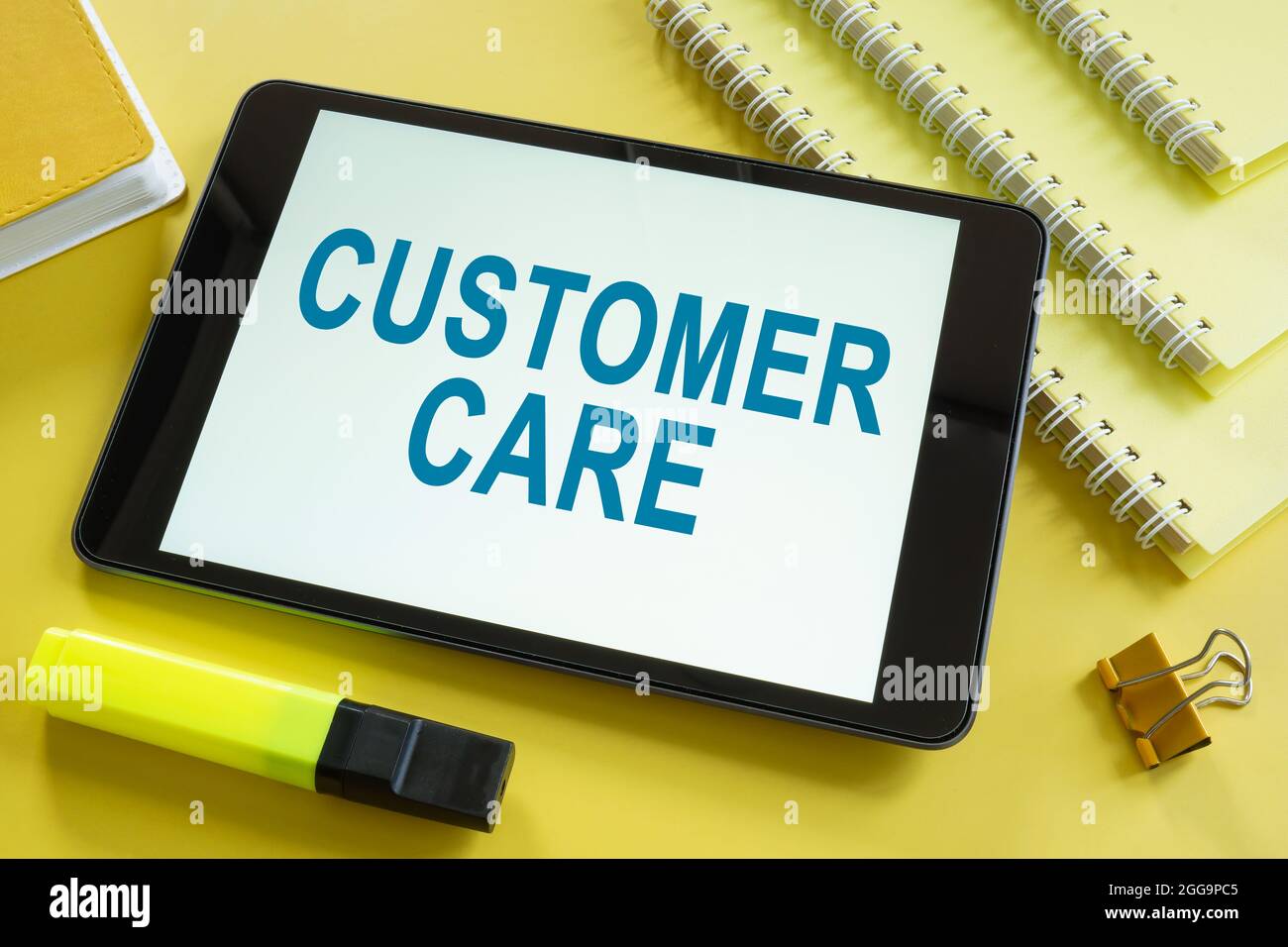 Customer care on the screen and notepads Stock Photo - Alamy