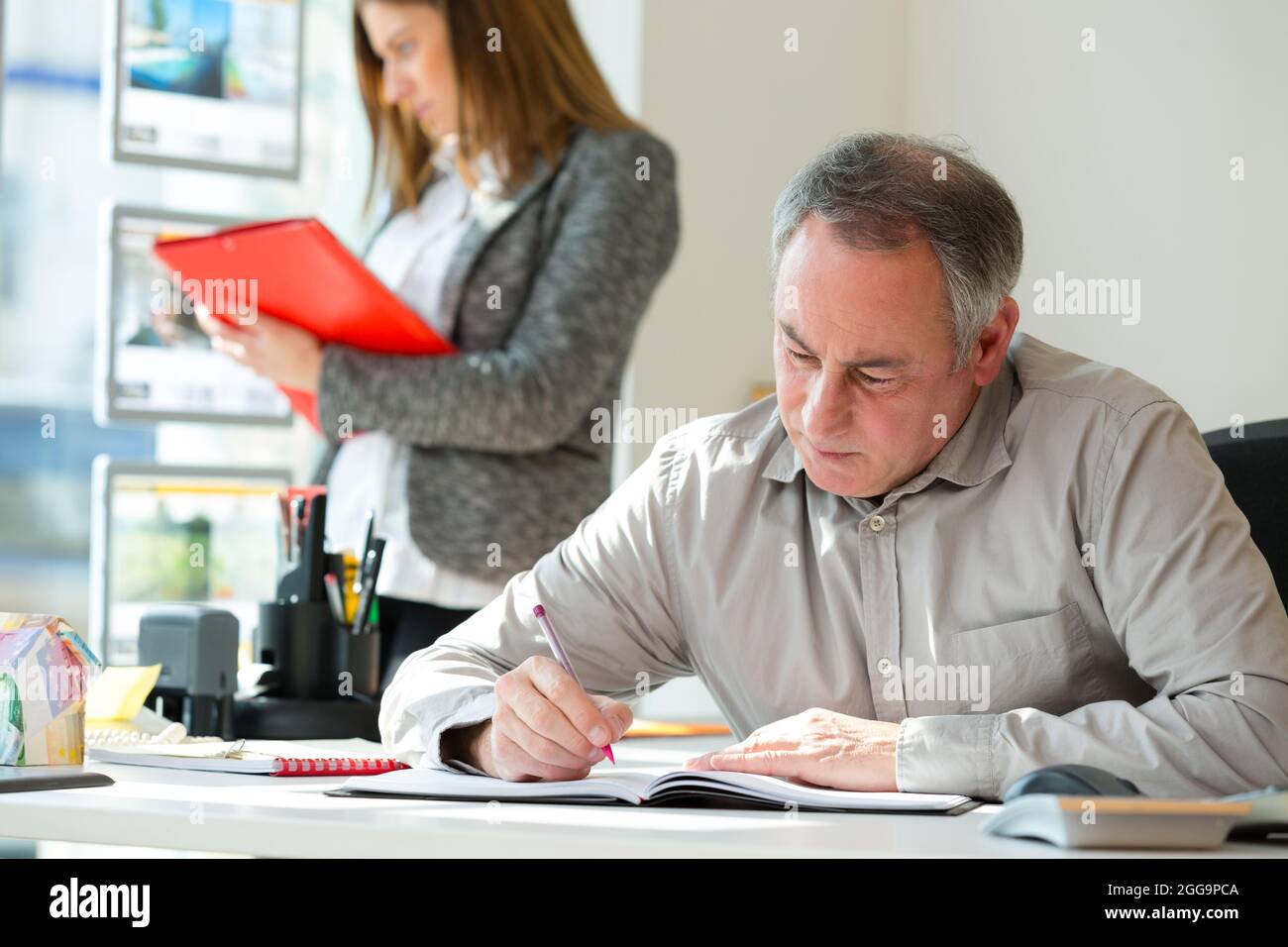 male estate agent working at office desk Stock Photo - Alamy