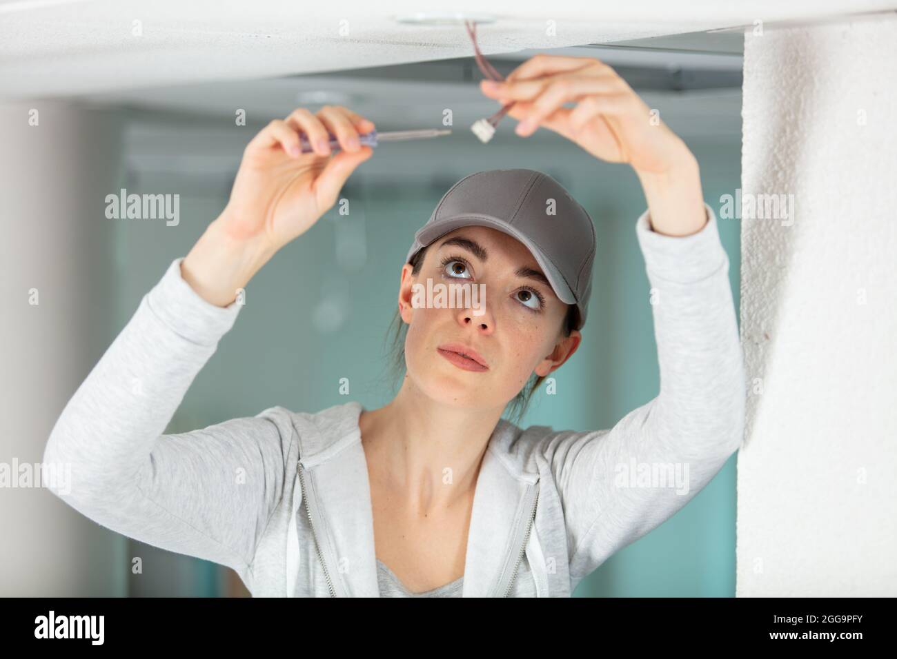 young standing on a ladder changing a light bulb Stock Photo - Alamy