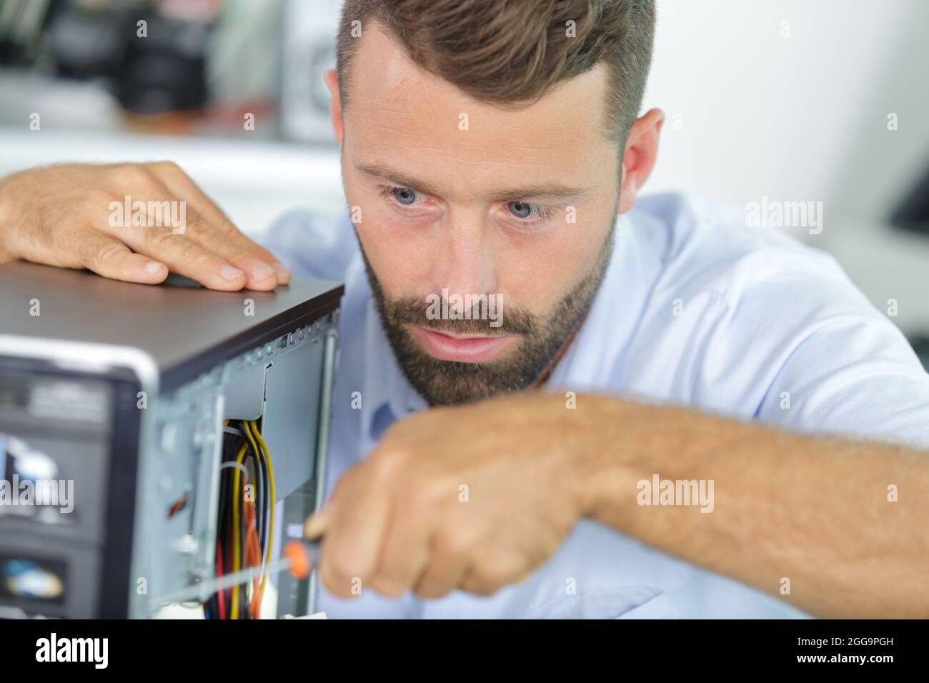 male worker fixing a pc Stock Photo - Alamy