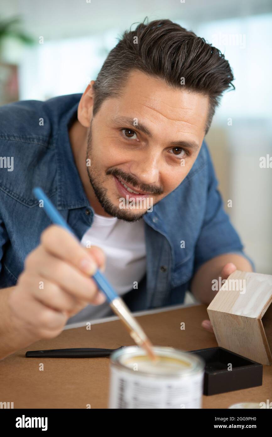 diy man painting small wood box at home Stock Photo - Alamy