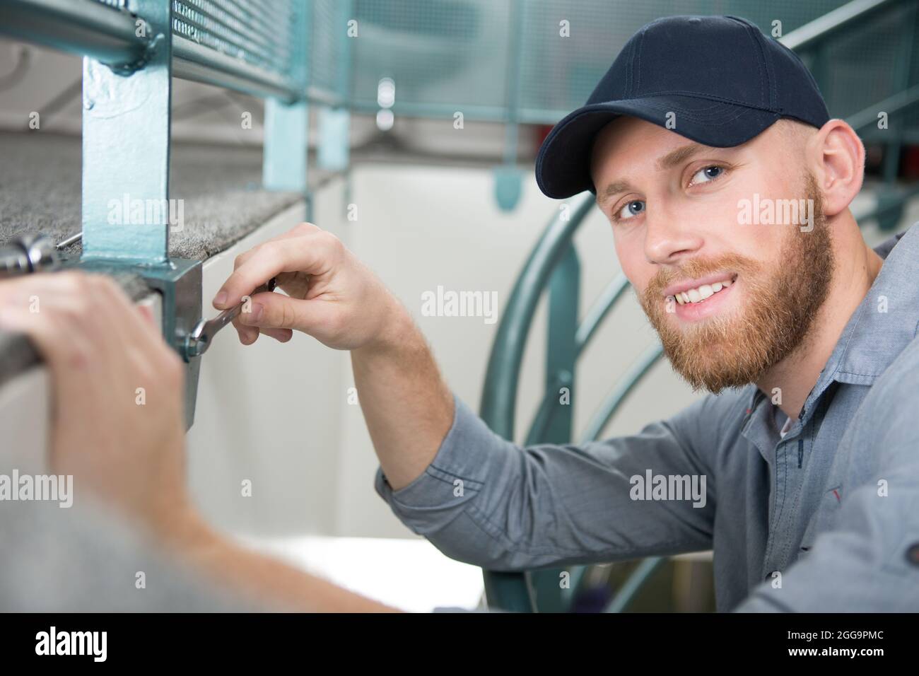 man fitting a bolt on a step Stock Photo - Alamy