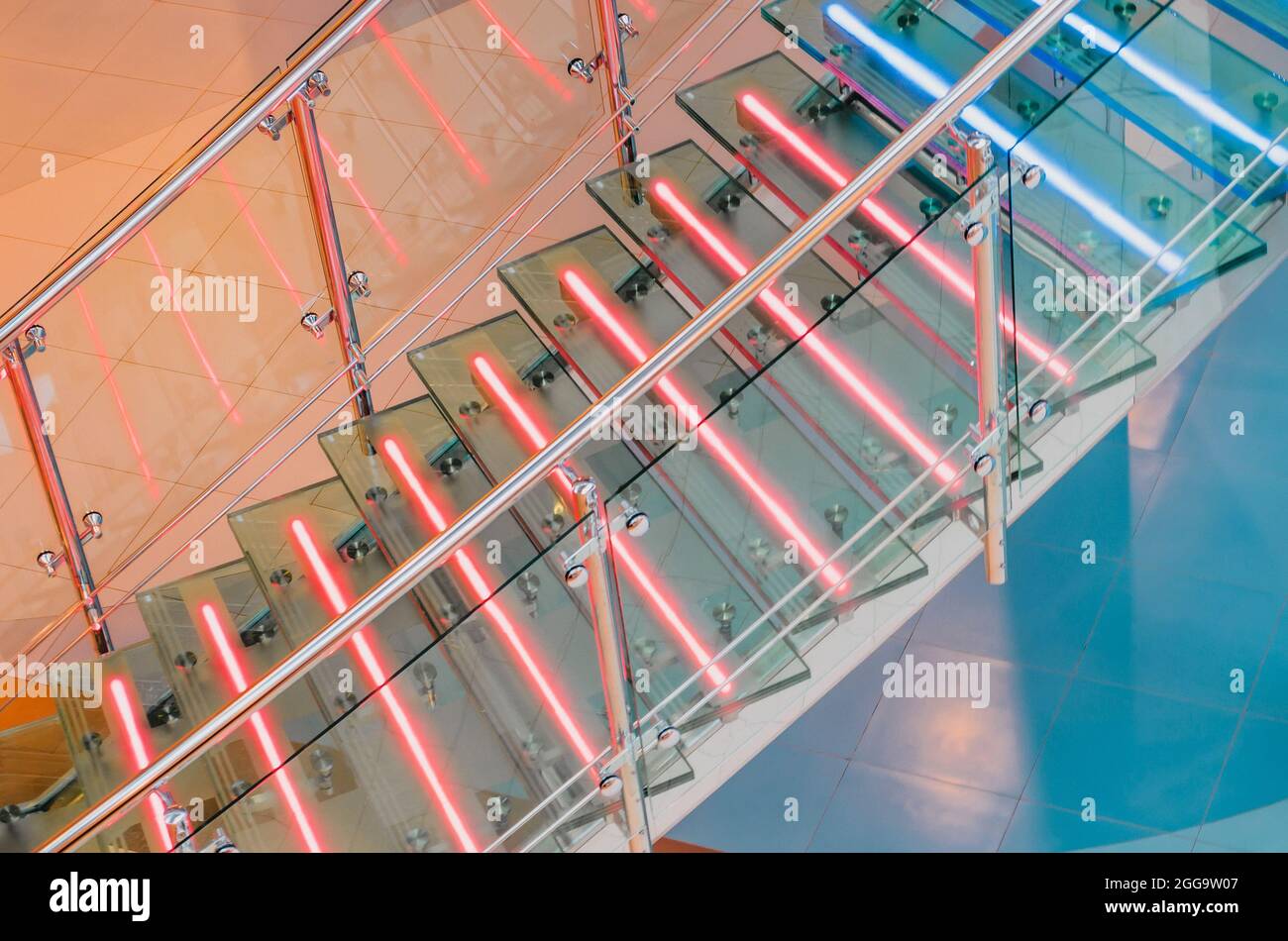 Metal glass staircase with neon, led backlight Stock Photo - Alamy