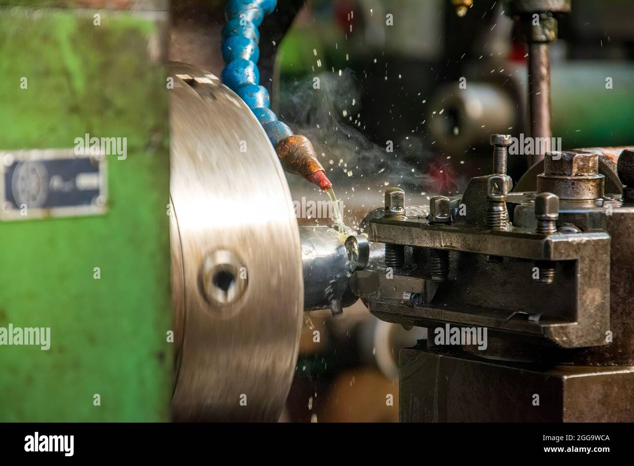 Turning a bar of metal on a lathe Stock Photo - Alamy