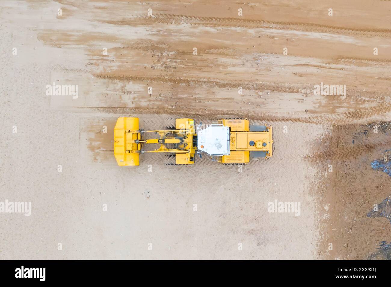 Aerial view of the working yellow earth mover grader flattens the ...