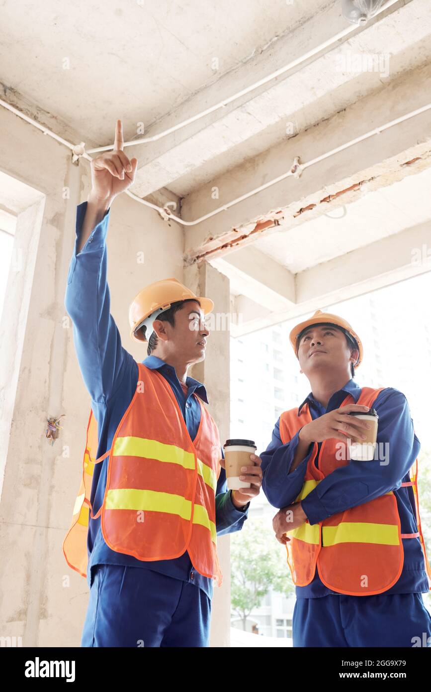 Contractors drinking morning coffee and discussing ceiling slabs and ...