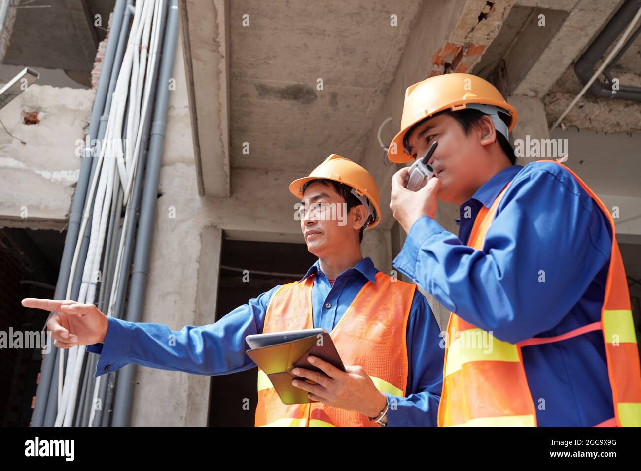 Contractors with tablet computer using walkie-talkie to control work of ...