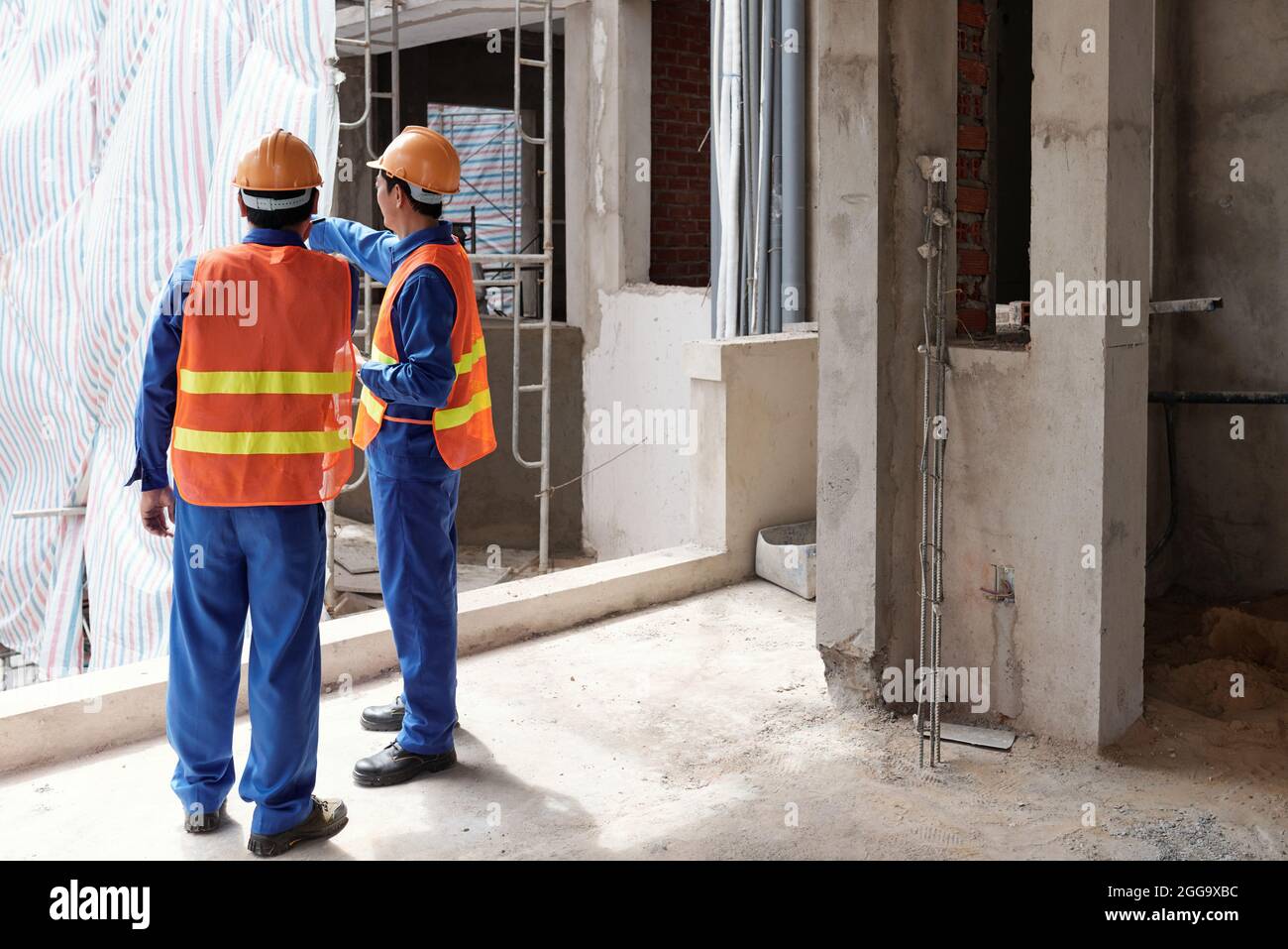 Head contractor showing site to construction manager and explaining ...