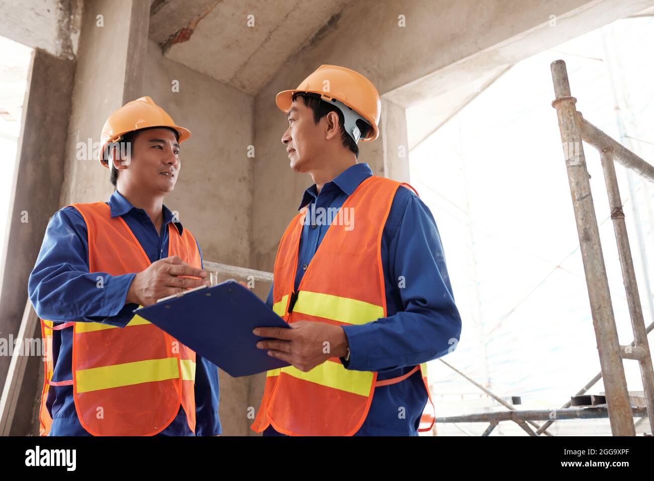 Builders in uniform discussing plan of work for the day when meeting at ...