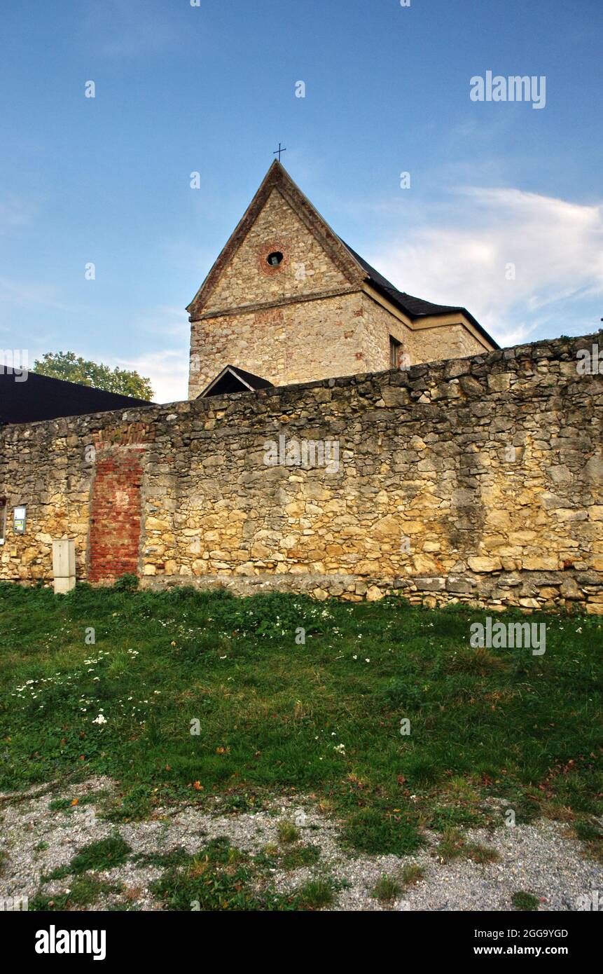 Medieval monastery with beautiful blue sky, stone wall and green bush ...