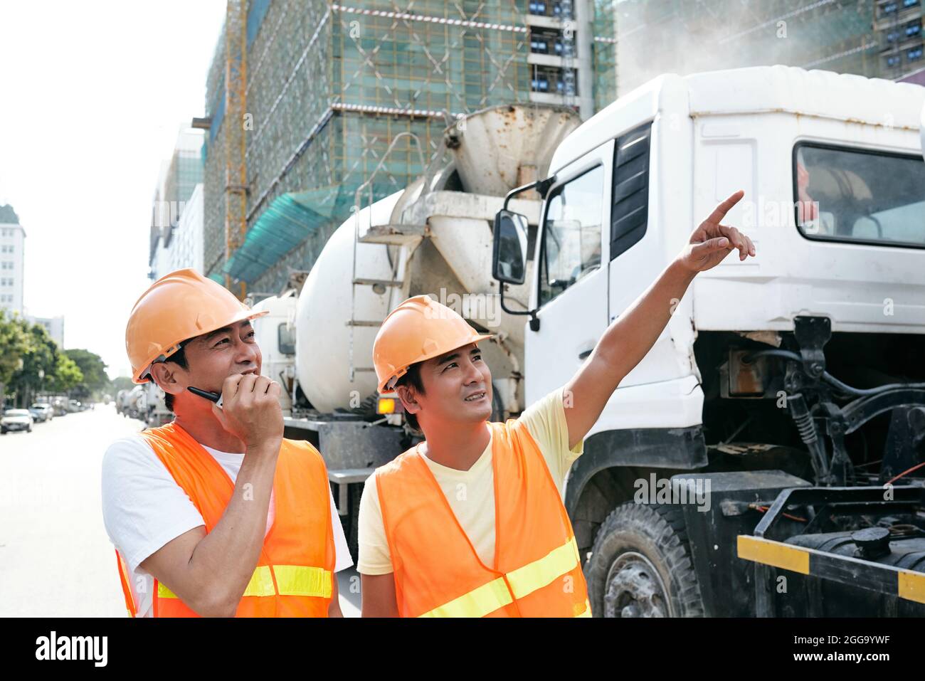 Contractor pointing at building under construction when his coworker ...