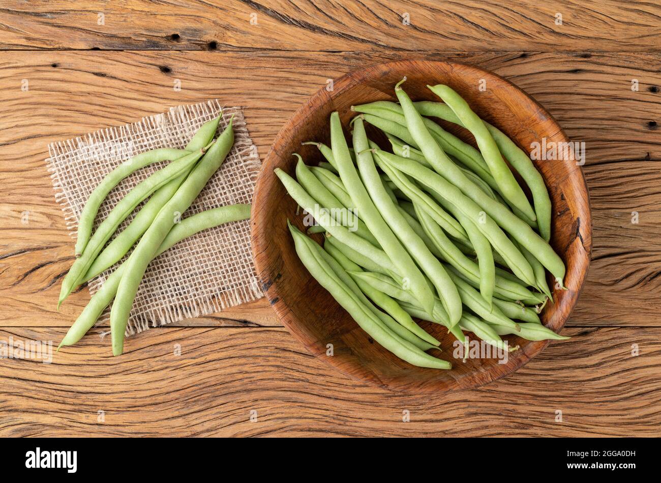 A group of green bean pods in a bowl over wooden table Stock Photo - Alamy