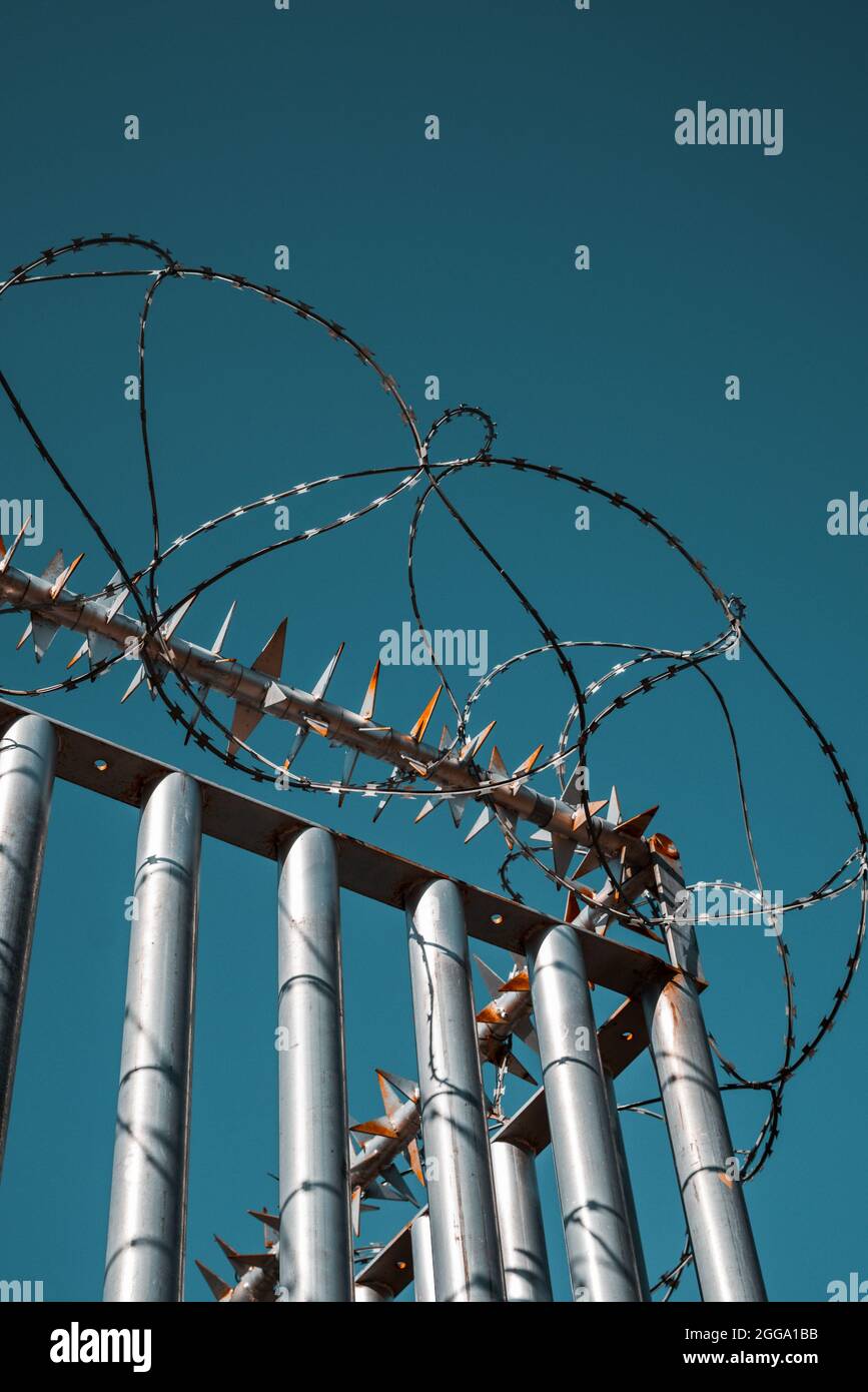 Vertical shot of a barbed-wire fence on sky background in Seville ...