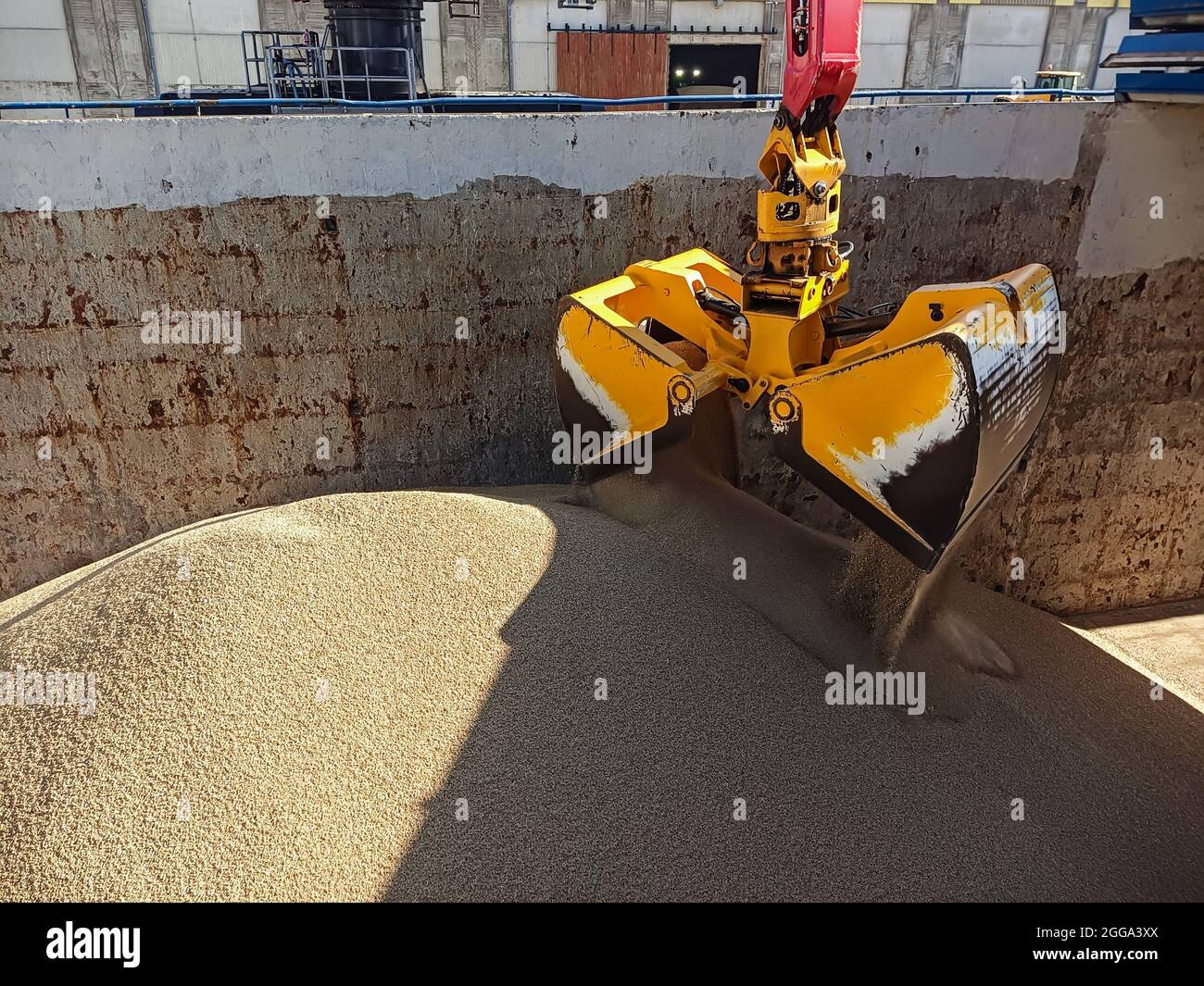 a crane with a manipulator bucket loads coal onto a dry cargo ship in ...