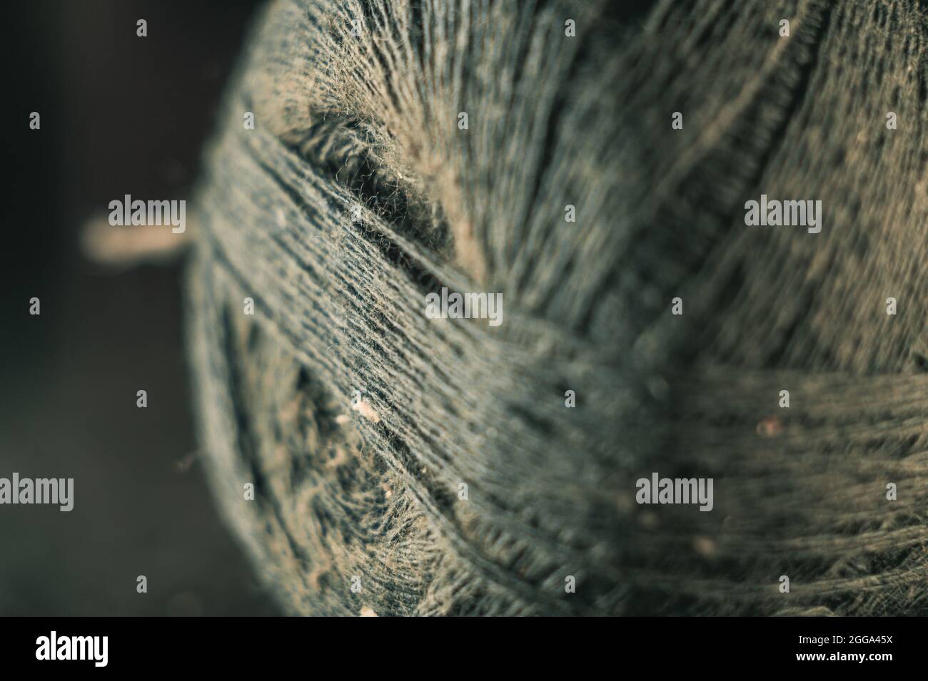 Selective focus shot of a stack of gray yarn for knitting under ...