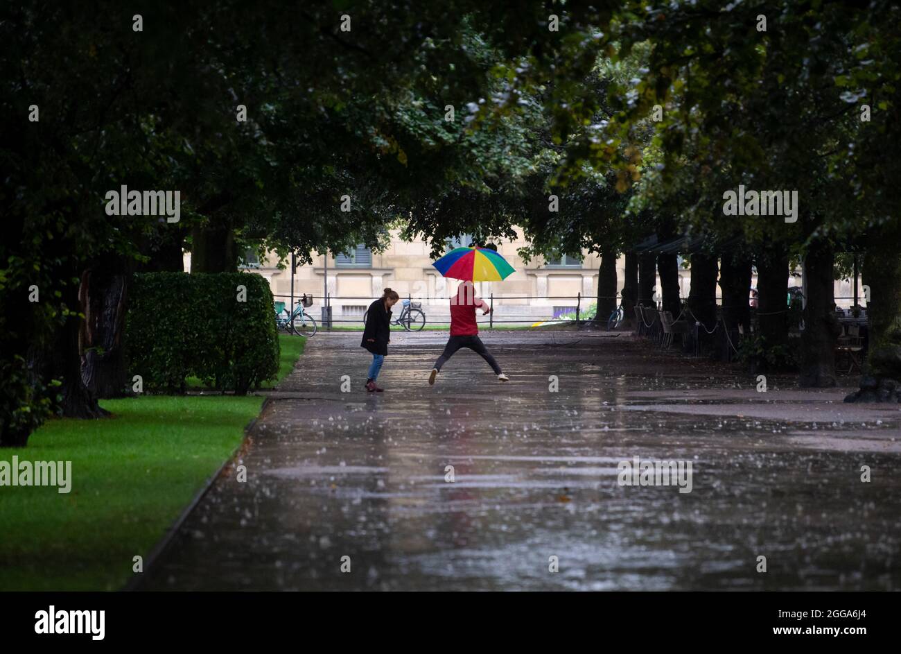 Munich, Germany. 30th Aug, 2021. A man and a woman walk through the ...