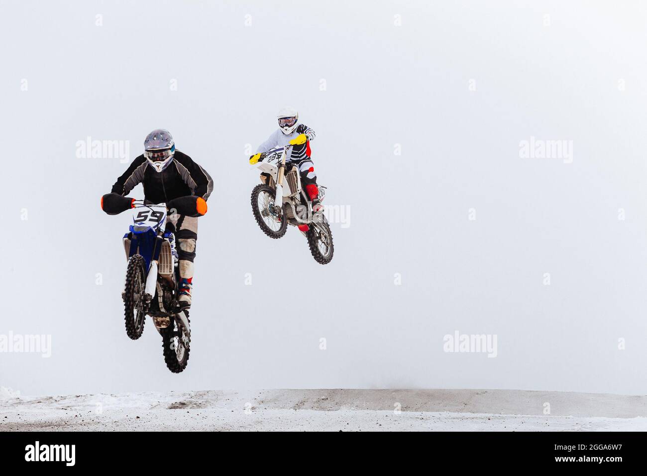 two motorcycle racers jump winter enduro race Stock Photo - Alamy