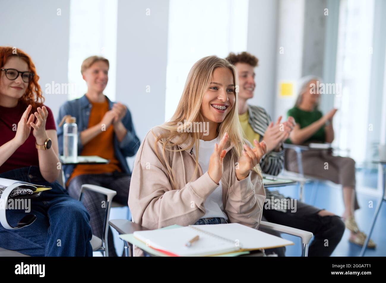 Portrait of group of university students sitting in classroom indoors ...