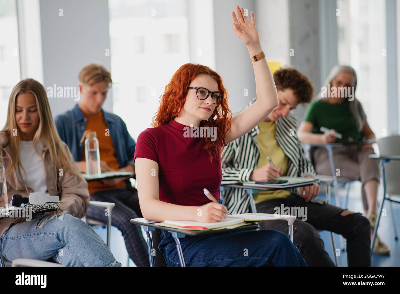 Portrait of group of university students sitting in classroom indoors ...