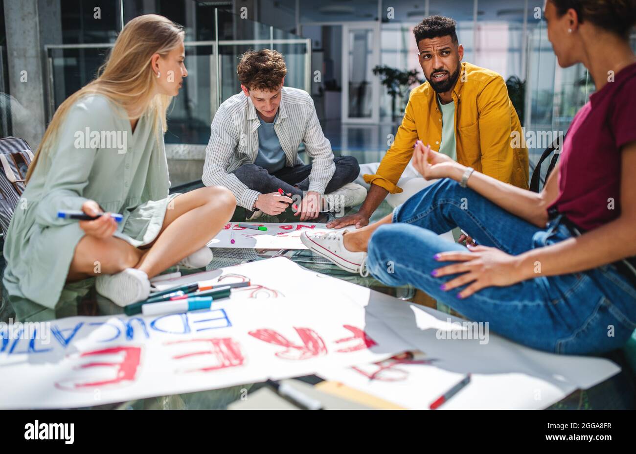 University students activists making banners for protest indoors ...