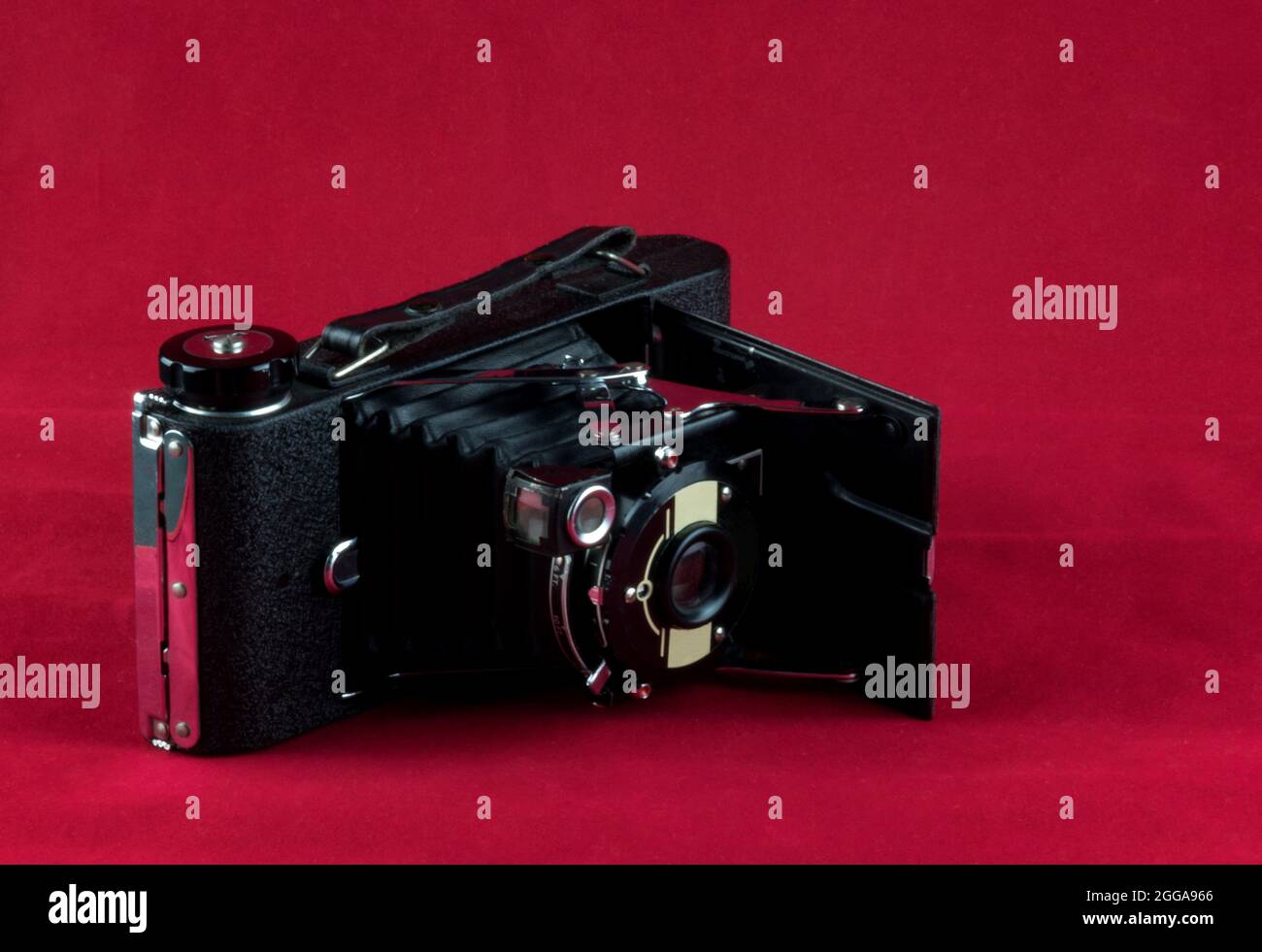 Old bellows film camera isolated on a red background Stock Photo - Alamy
