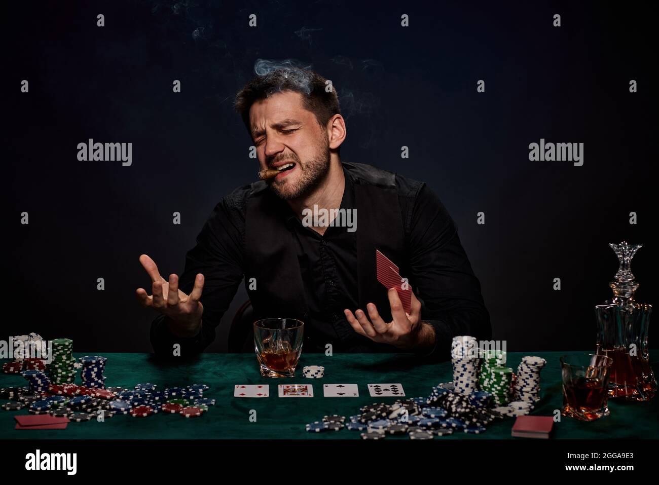 Bearded casino player man playing poker on green table Stock Photo - Alamy
