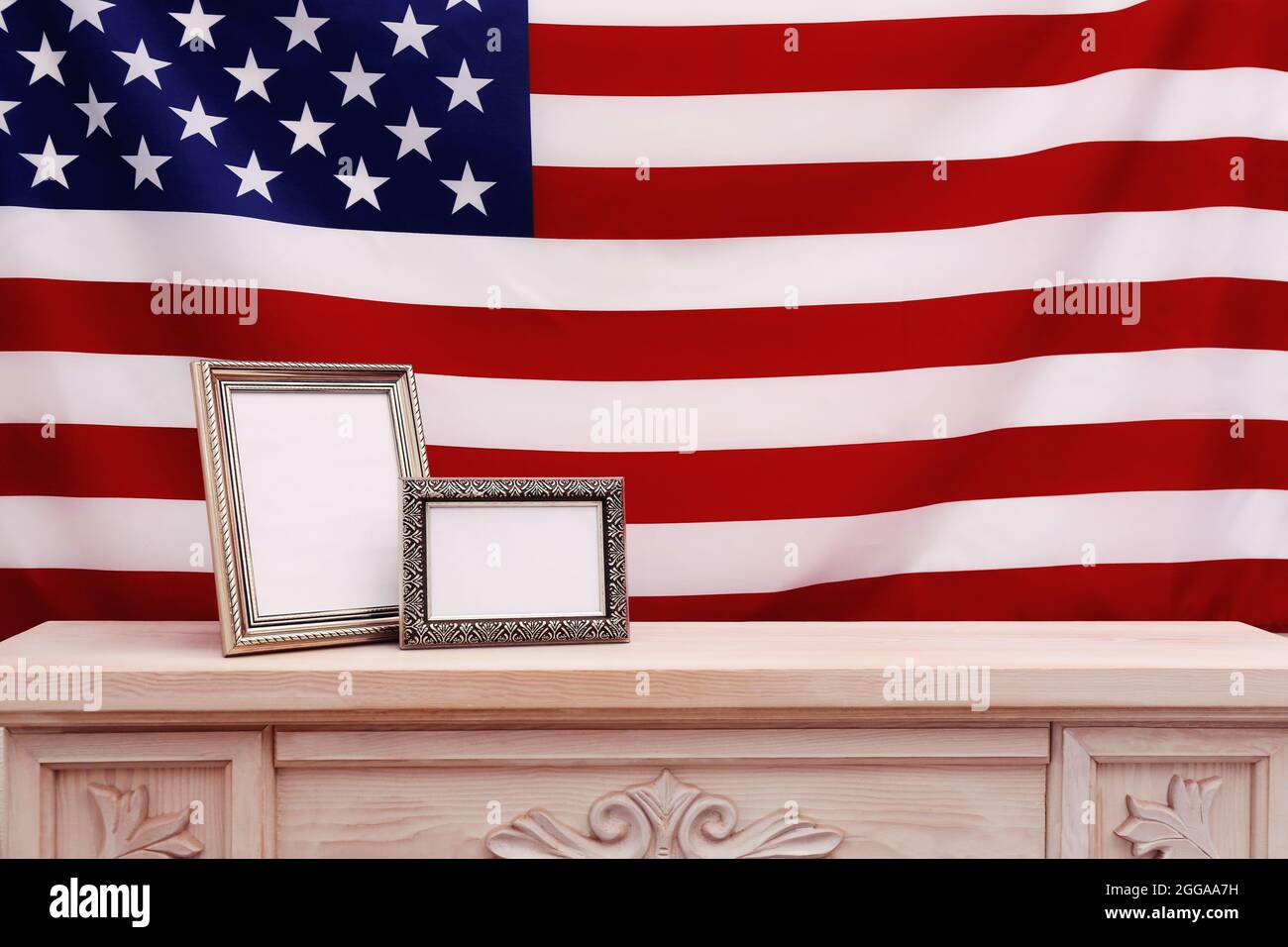 Two photo frames with USA flag on wooden mantelpiece Stock Photo - Alamy