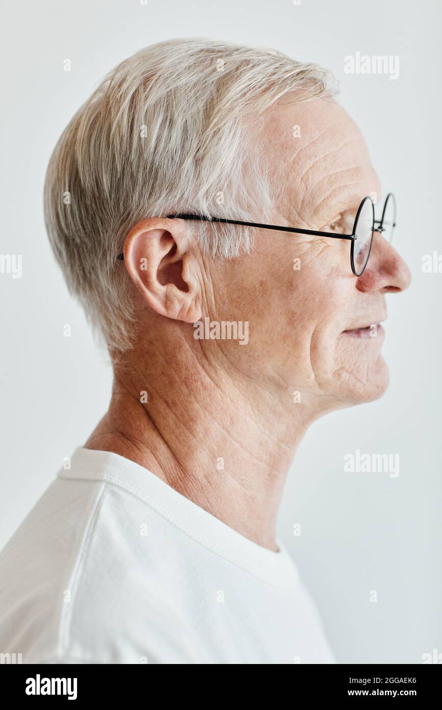Minimal side view portrait of white haired senior man on white ...
