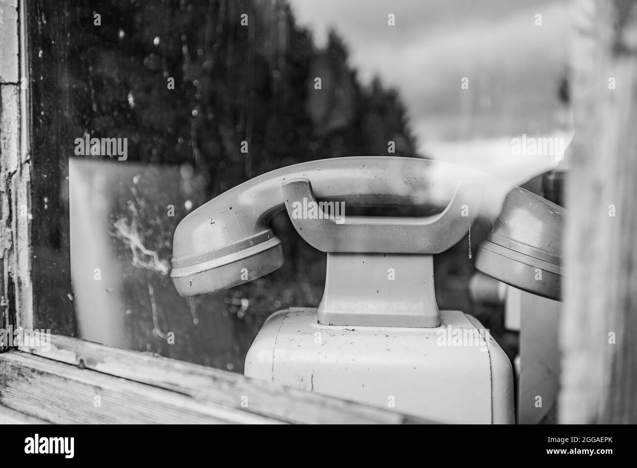 Grayscale of a vintage telephone behind the glass Stock Photo - Alamy