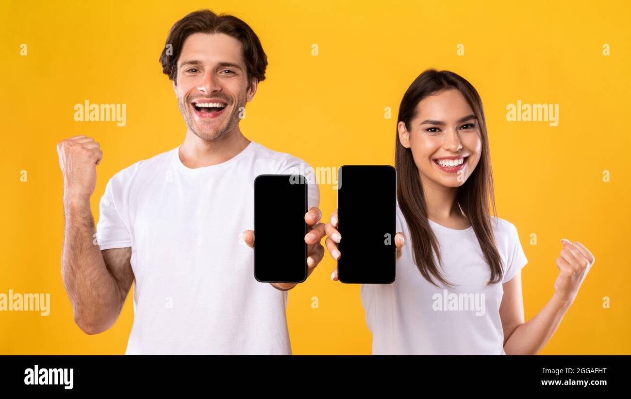 Couple showing two empty smartphone screens gesturing yes Stock Photo ...