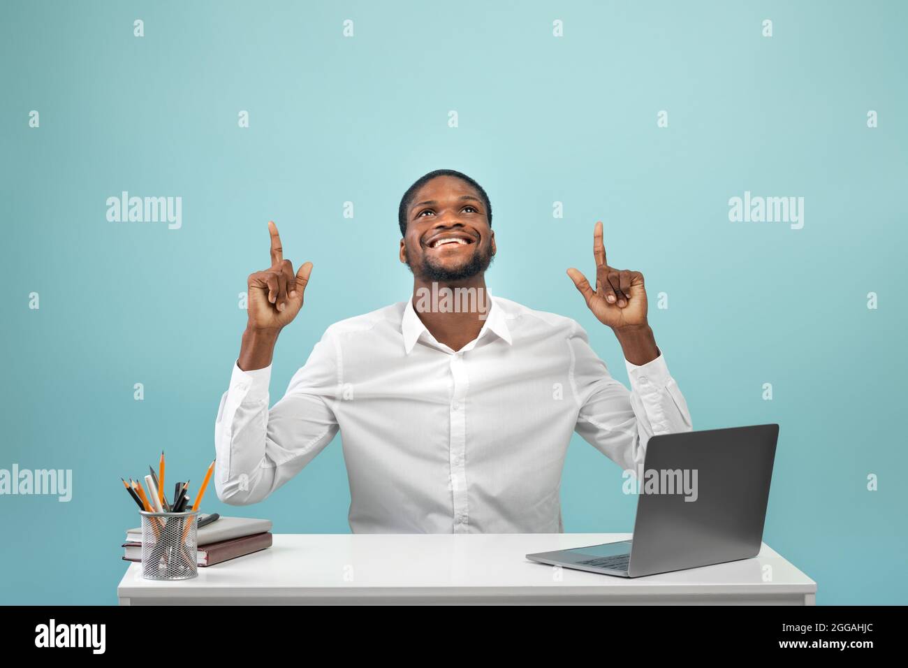 Young black businessman sitting at workplace with pc laptop point ...