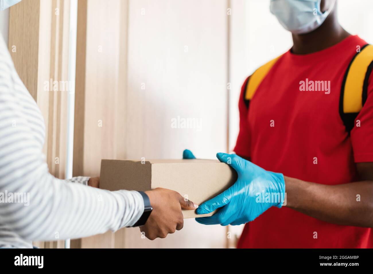 Unrecognizable African Delivery Man Giving Woman Parcel At Her Doors ...