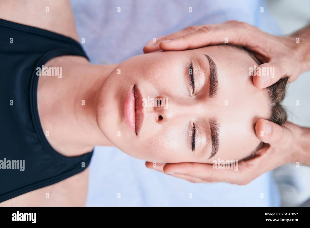Beautiful male hands holding female head isolated in light background ...