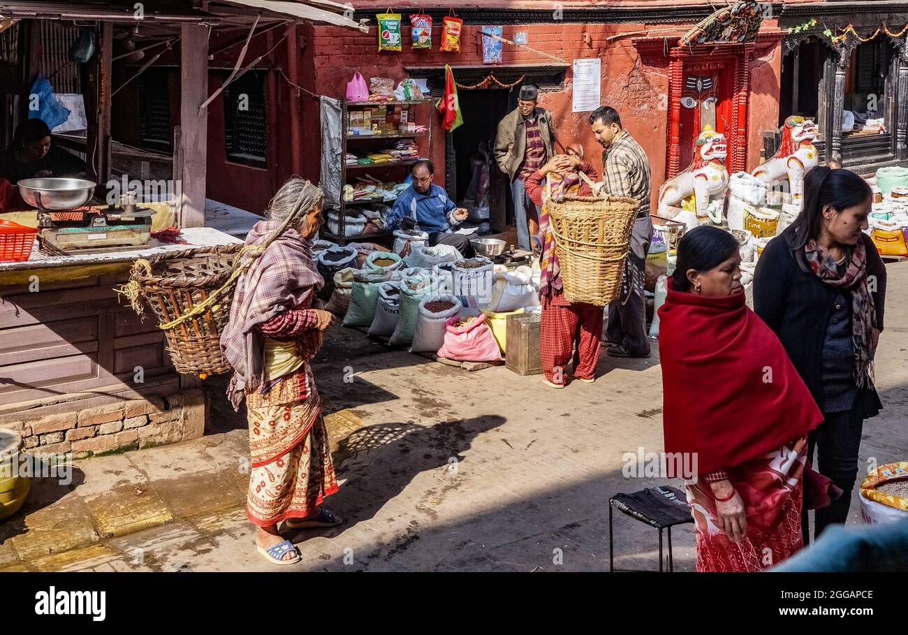 elderly Nepalese women carrying tumpline baskets with their forehead in ...