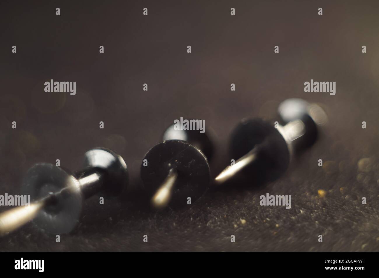 Closeup shot of black pushpins on a black surface Stock Photo - Alamy