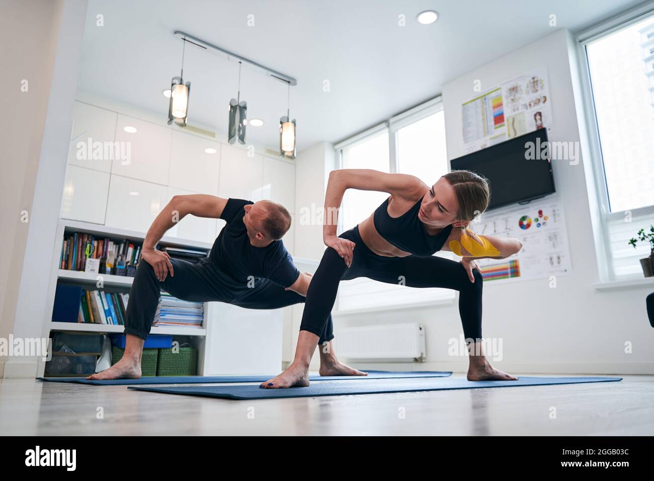 Beautiful female and neat strong man during the stretching exercises in ...