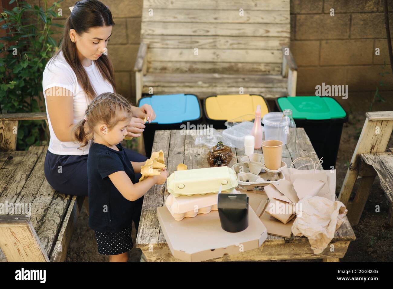Family sorting garbage at home on backyard. Concept of recycling ...