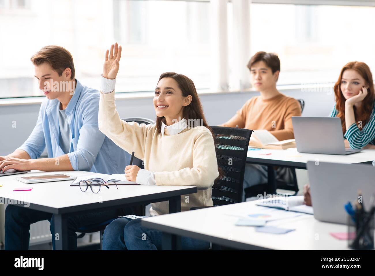 Portrait of female student raising hand at classroom Stock Photo - Alamy