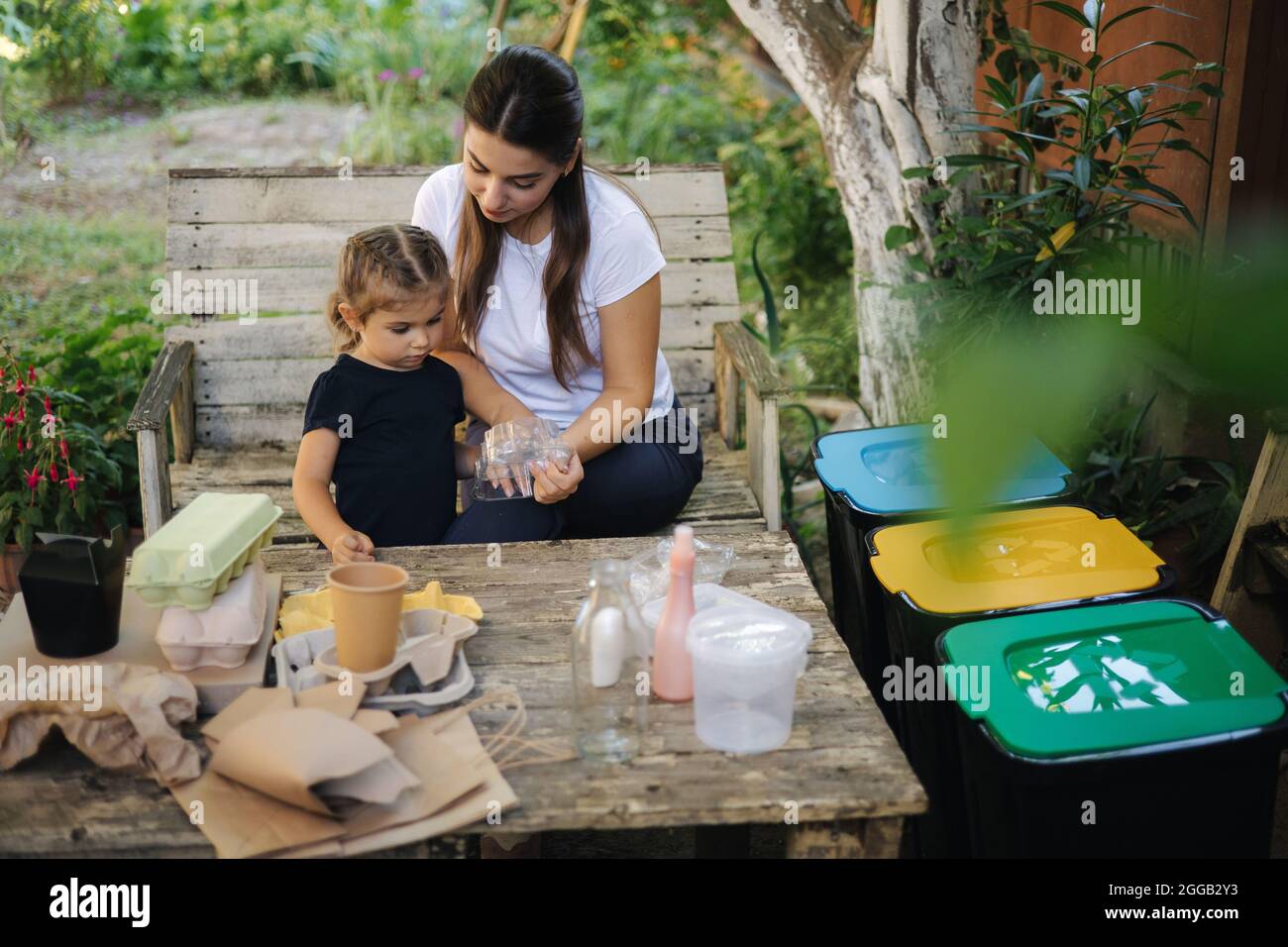 Family sorting garbage at home on backyard. Concept of recycling ...