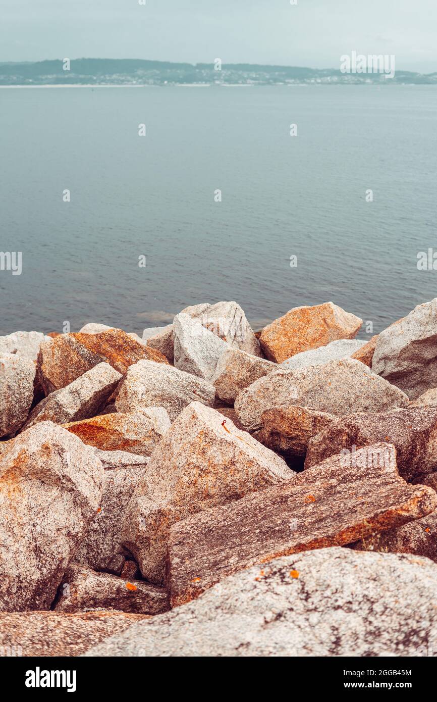 Seawall made of granite rocks piled up near the ocean Stock Photo - Alamy