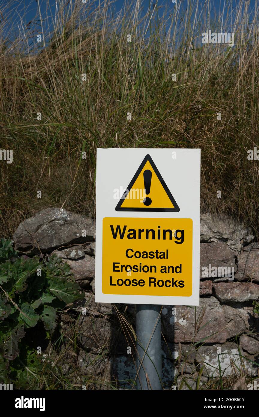 Yellow, black and white sign: Warning coastal erosion and loose rocks ...