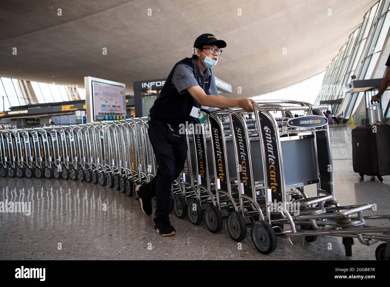 UNITED STATES - AUGUST 27: A worker moves Smarte Carte luggage carts in ...