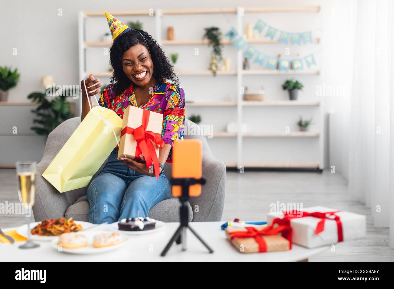 Black Lady Opening Birthday Present Near Phone Having Party Indoor ...