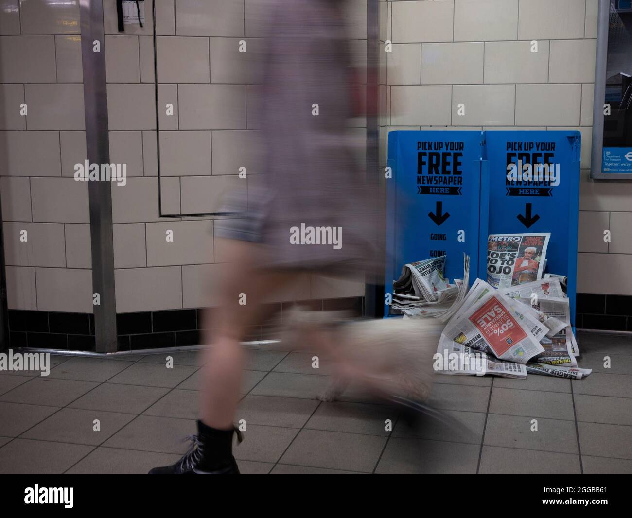 commuters walk past bin for free London Metro newspapers in London ...